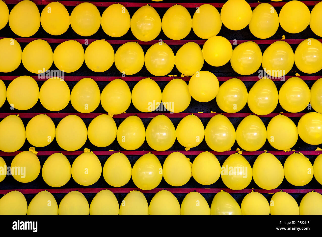 inflated yellow balloon carnival game on wood wall Stock Photo - Alamy