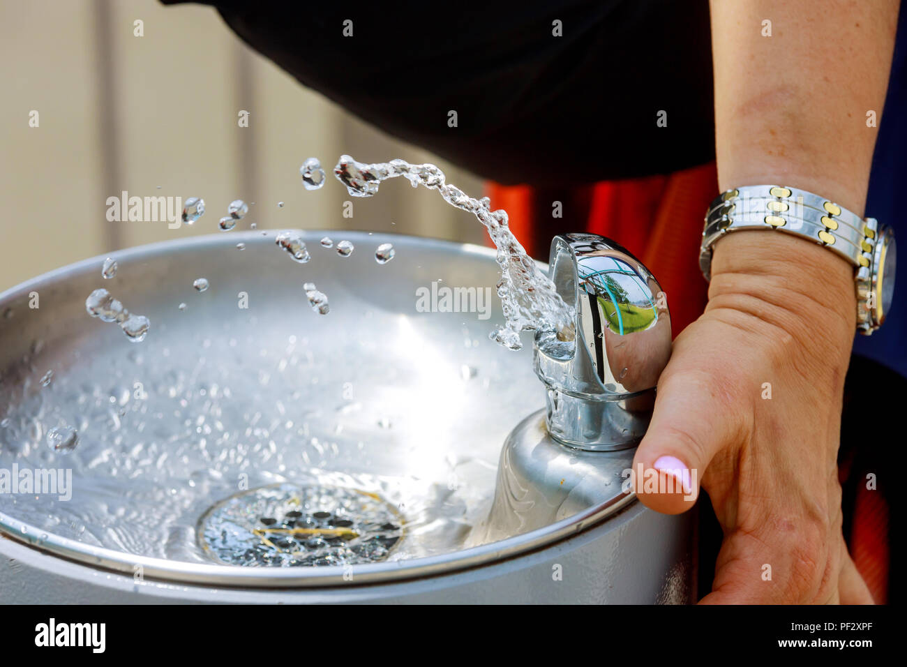 Drinking water thumb press the drinking water fountain Stock Photo - Alamy