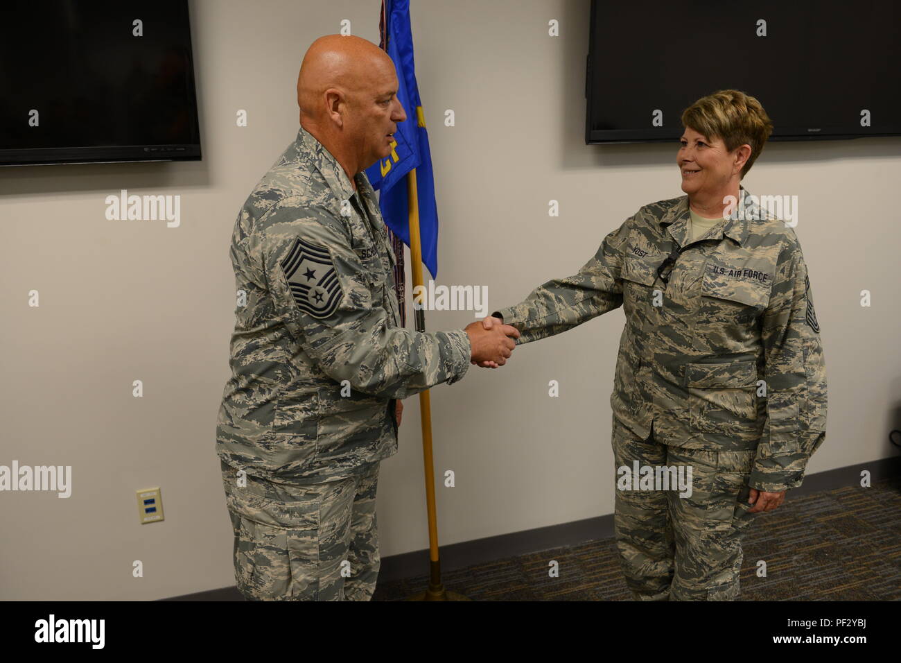 Command Chief Master Sergeant Ed Schellhase (left) presents his coin to ...