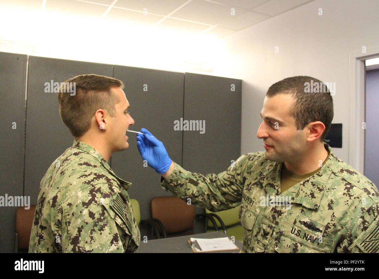 Hospital Corpsman Second Class Eric Halpert swabs the cheek of a ...