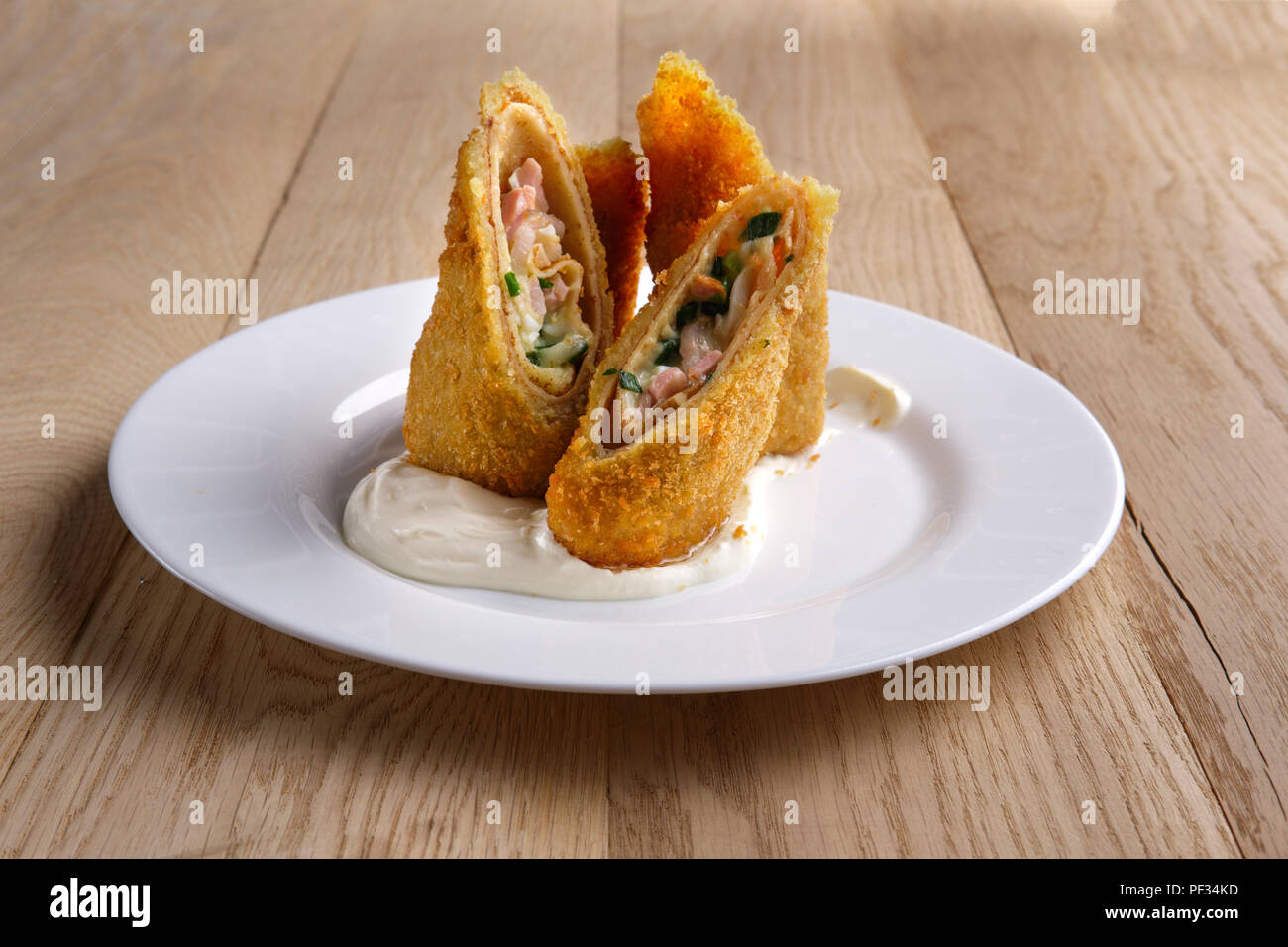 Deep-fried pancakes stuffed with ham and covered with melted cheese ...