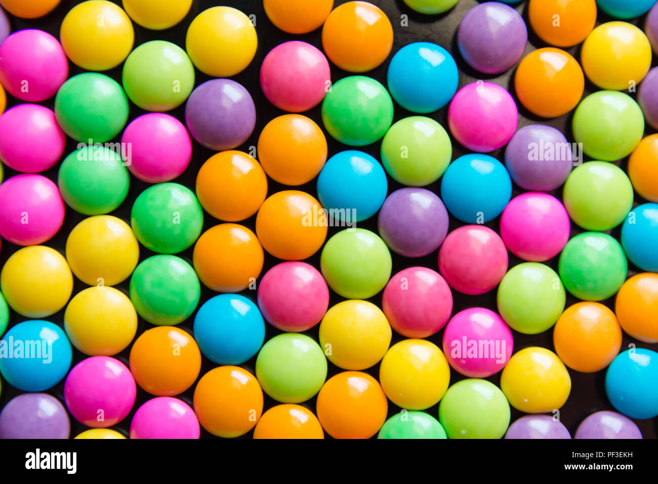 Pile of colorful sweet candy chocolates coated background. colourful ...