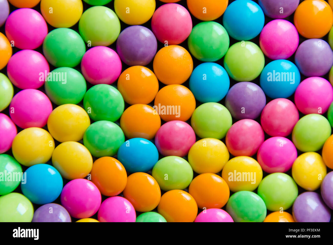 Pile of colorful sweet candy chocolates coated background. colourful ...