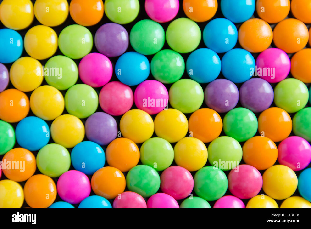 Pile of colorful sweet candy chocolates coated background. colourful ...