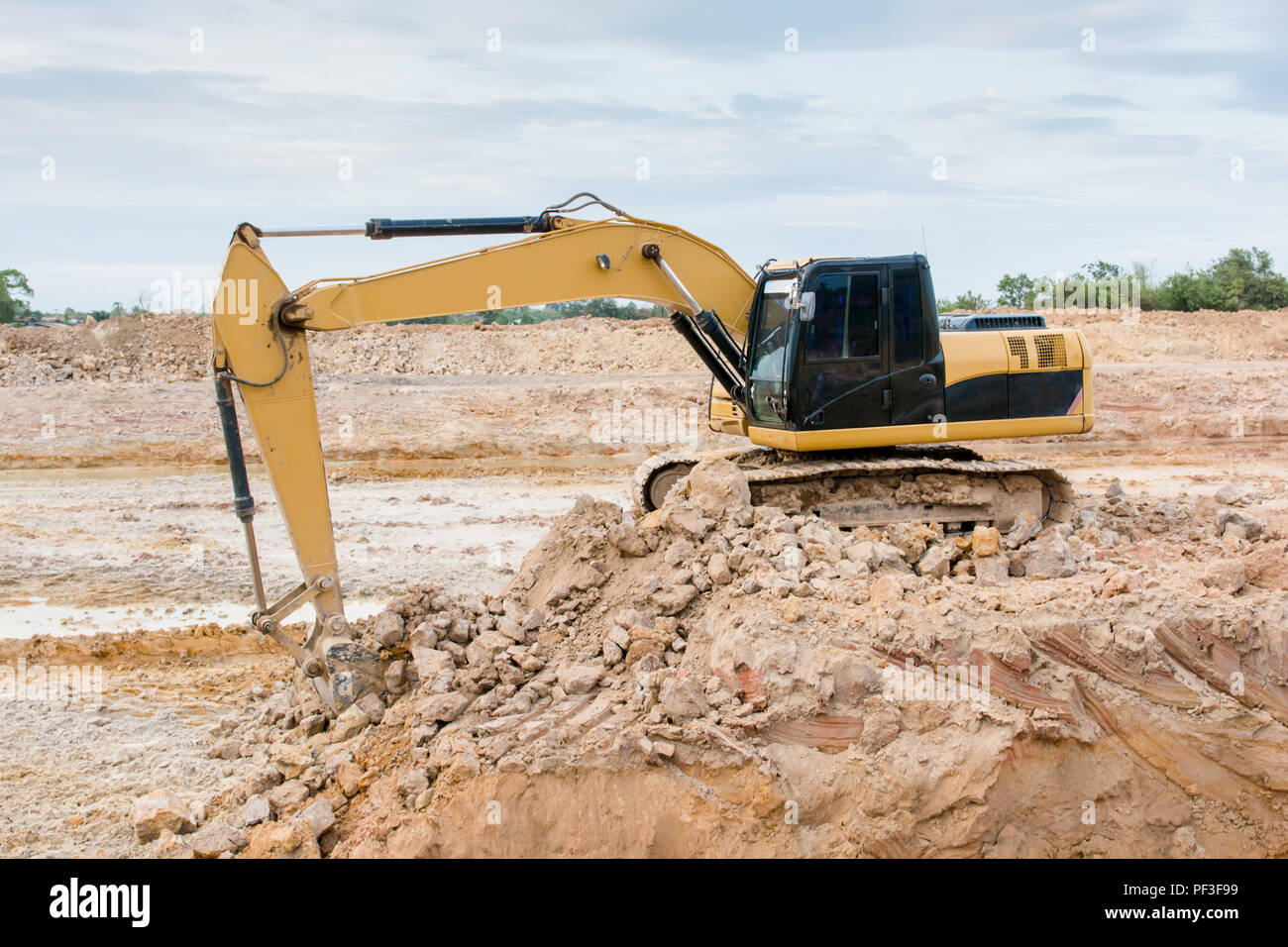 Yellow excavator machine working earth moving works at construction ...