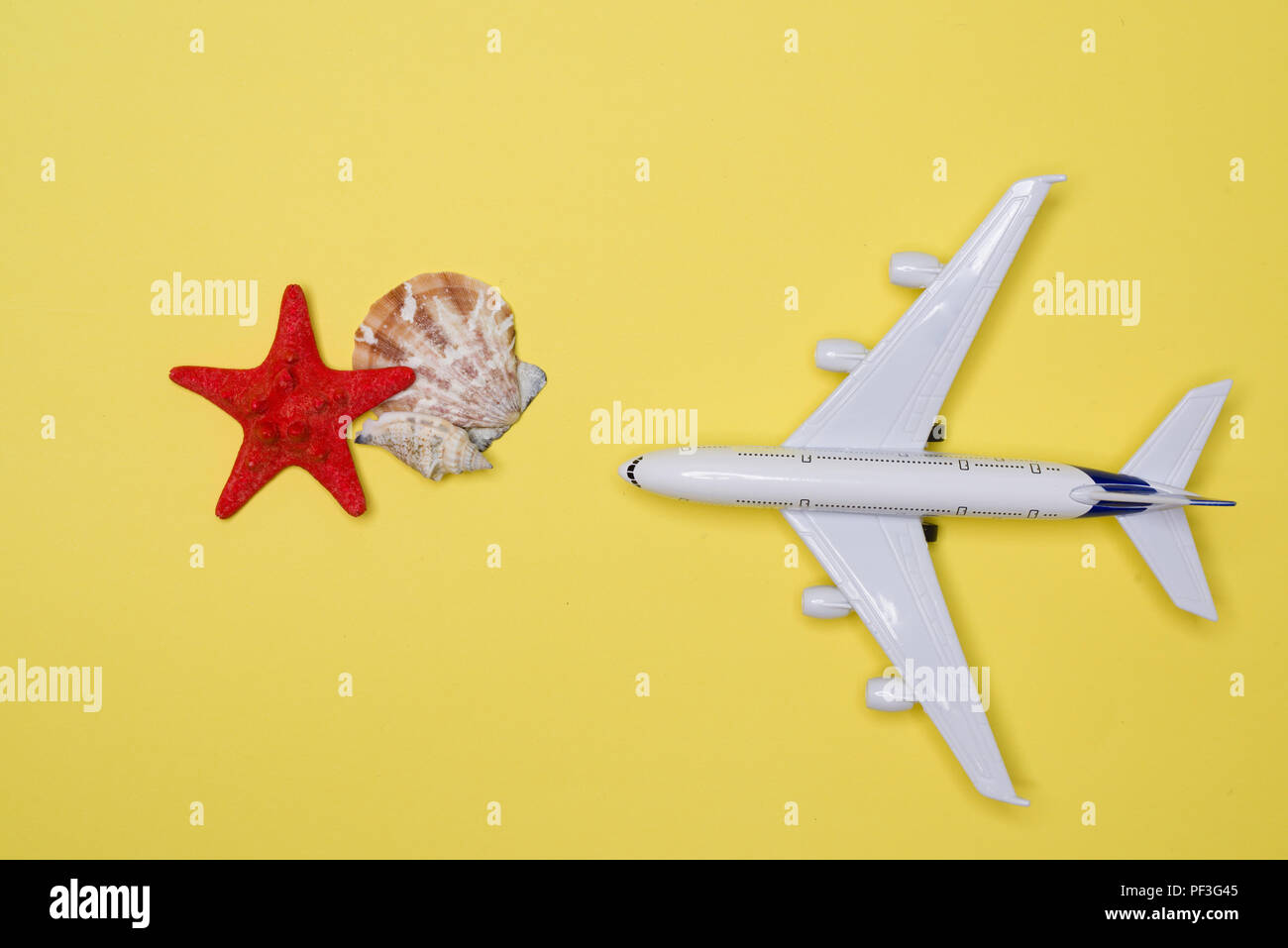 Travel airplane and start shells on yellow background Stock Photo - Alamy