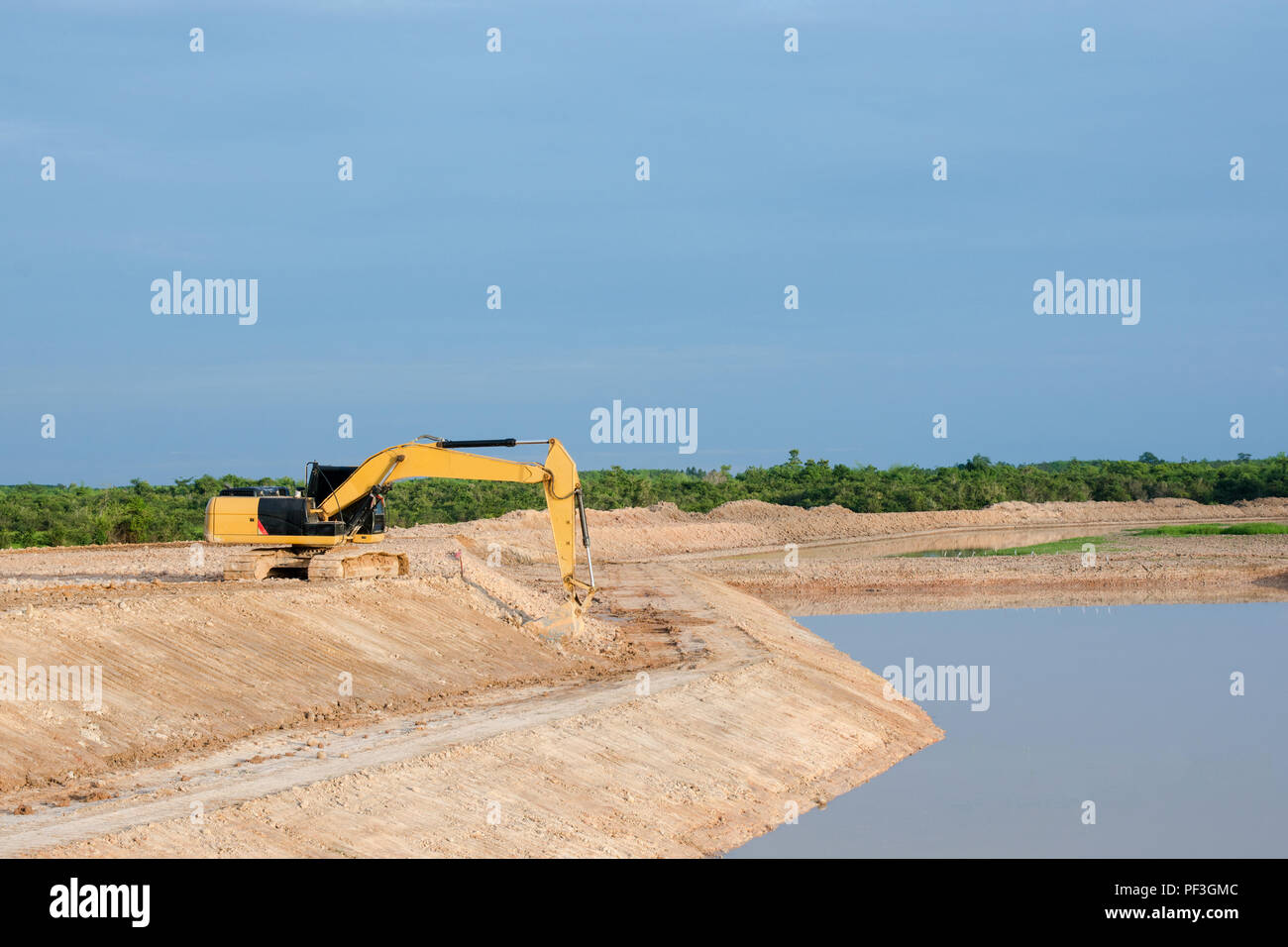 Yellow excavator machine working earth moving works riverside at ...