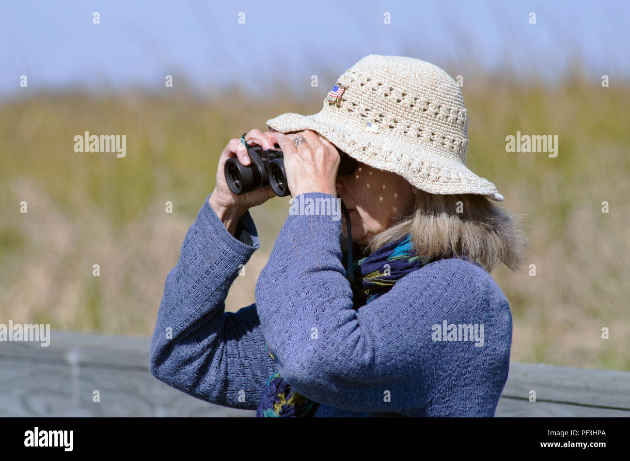 A woman with binoculars views wildlife at the Leonabelle Turnbull ...