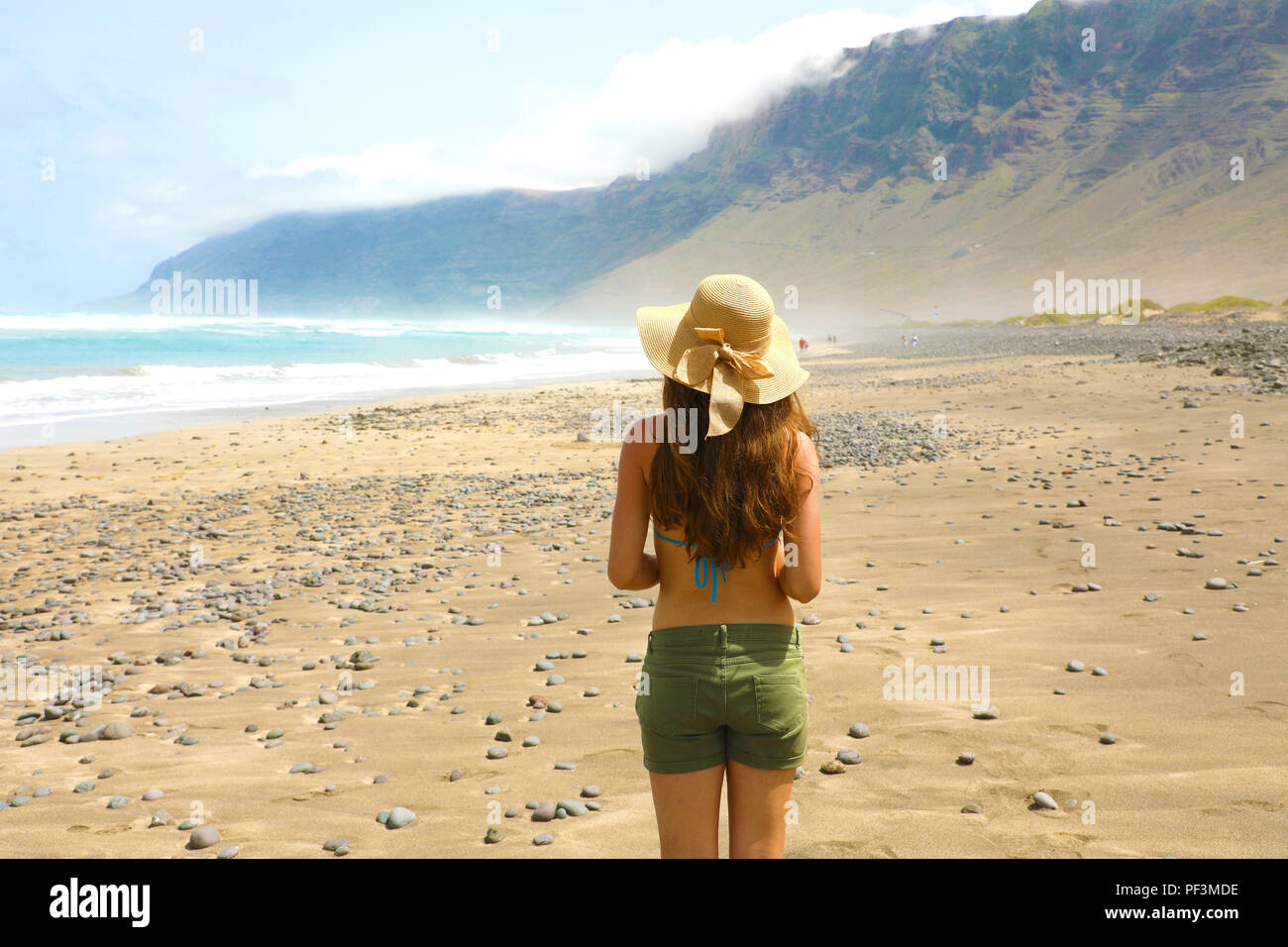 Beautiful girl with hat looking to suggestive landscape of Caleta ...