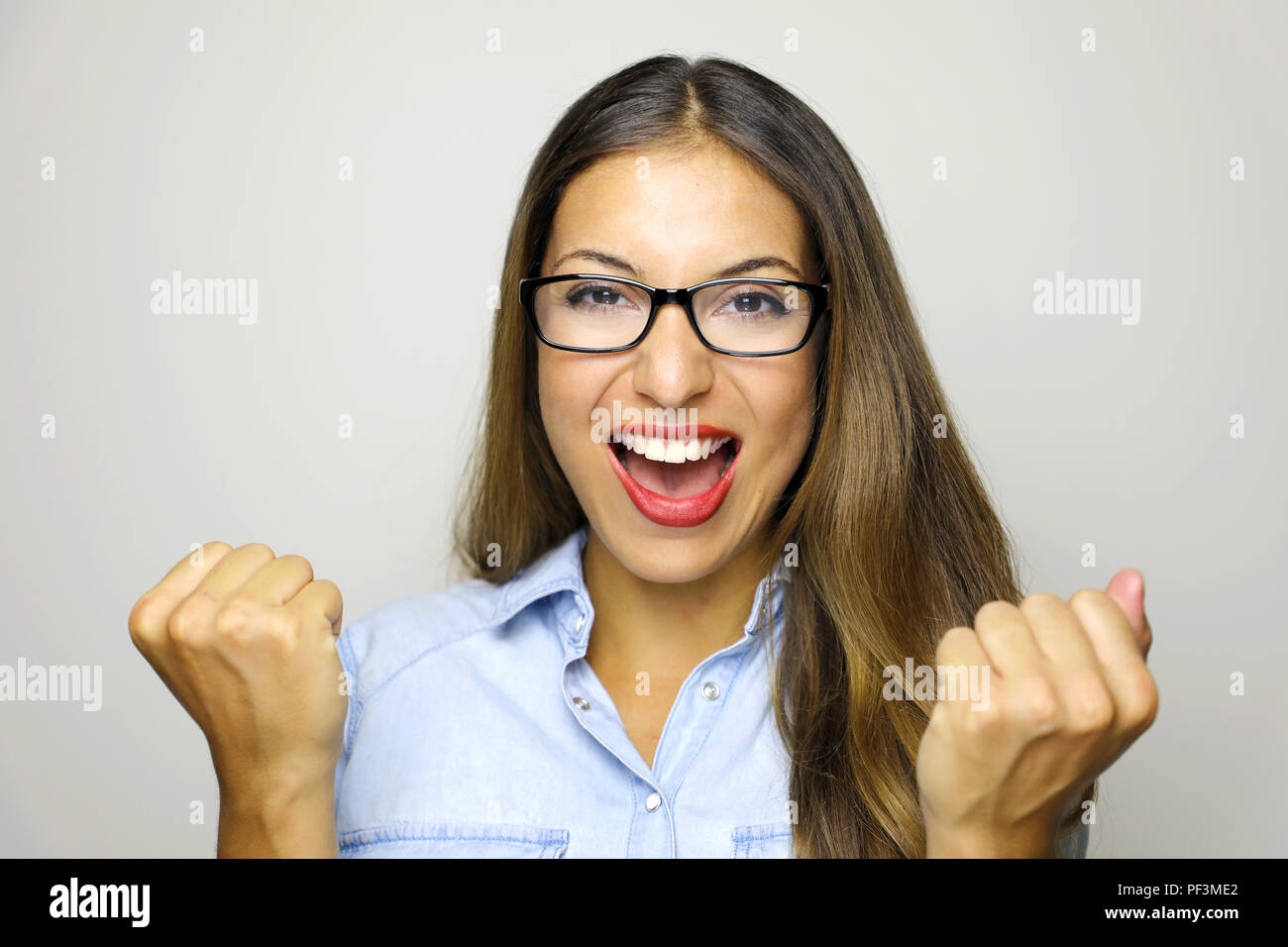 Happy determined young woman with raised hands shouting and celebrating ...