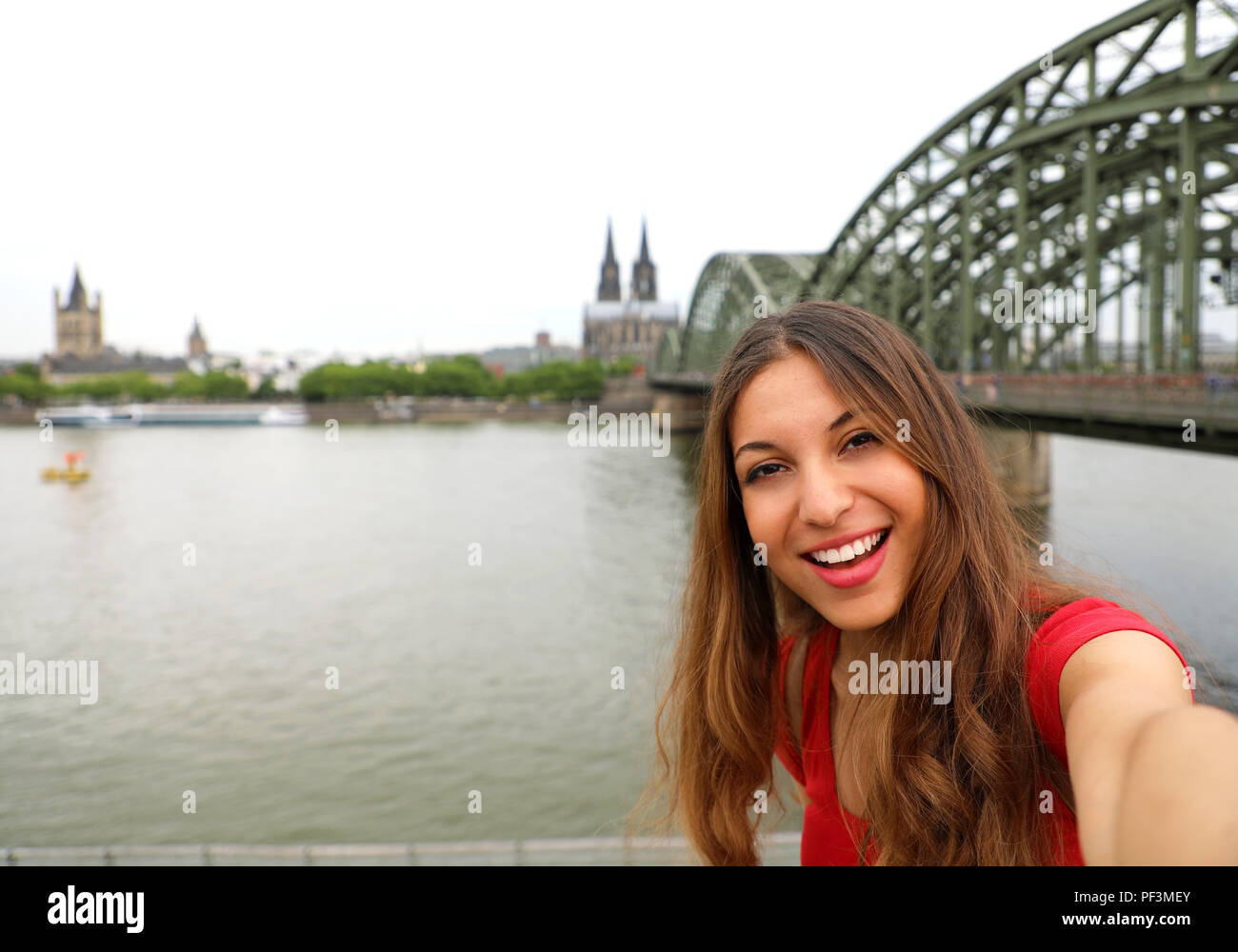 Selfie photo of woman in Cologne with Hohenzollern Bridge and Cathedral ...