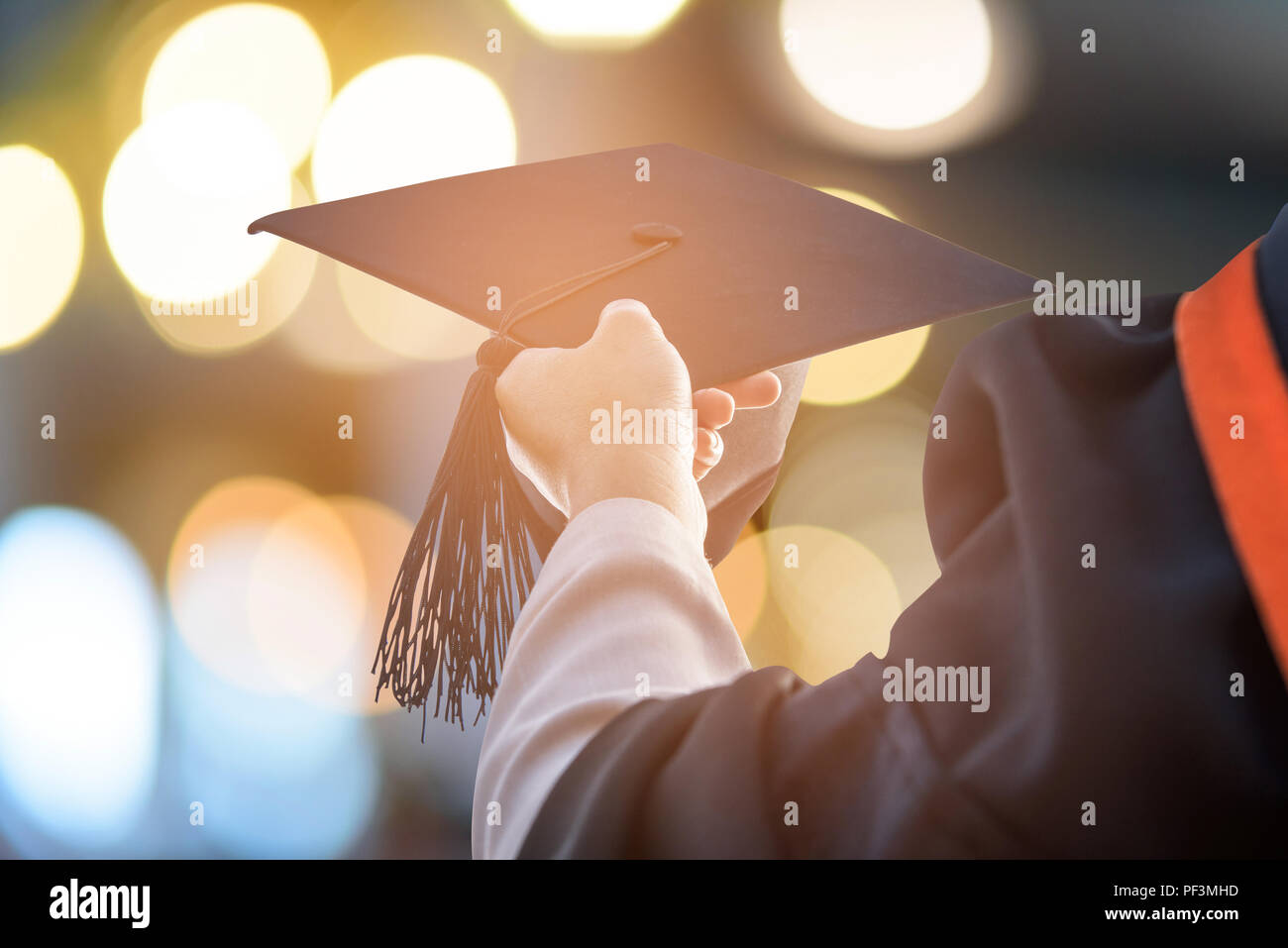 Graduation hold black tassel hat in front of bokeh Blurry background ...