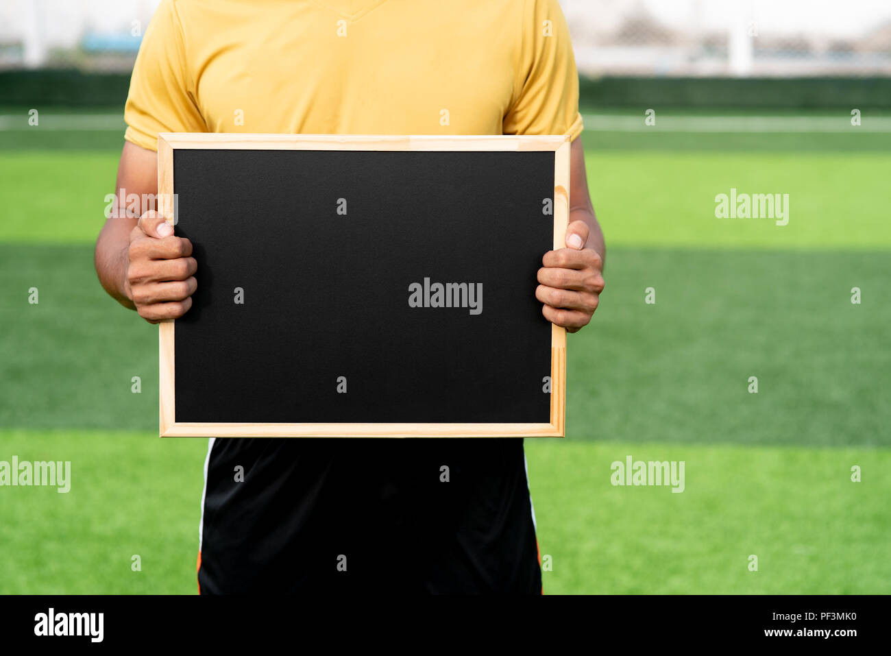 Men use handheld blackboard at soccer field Stock Photo - Alamy
