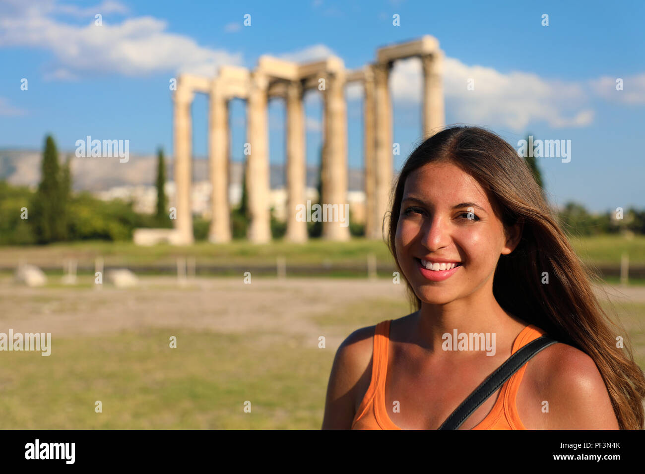 Smiling tourist woman with the greek temple of Olympian Zeus on the ...
