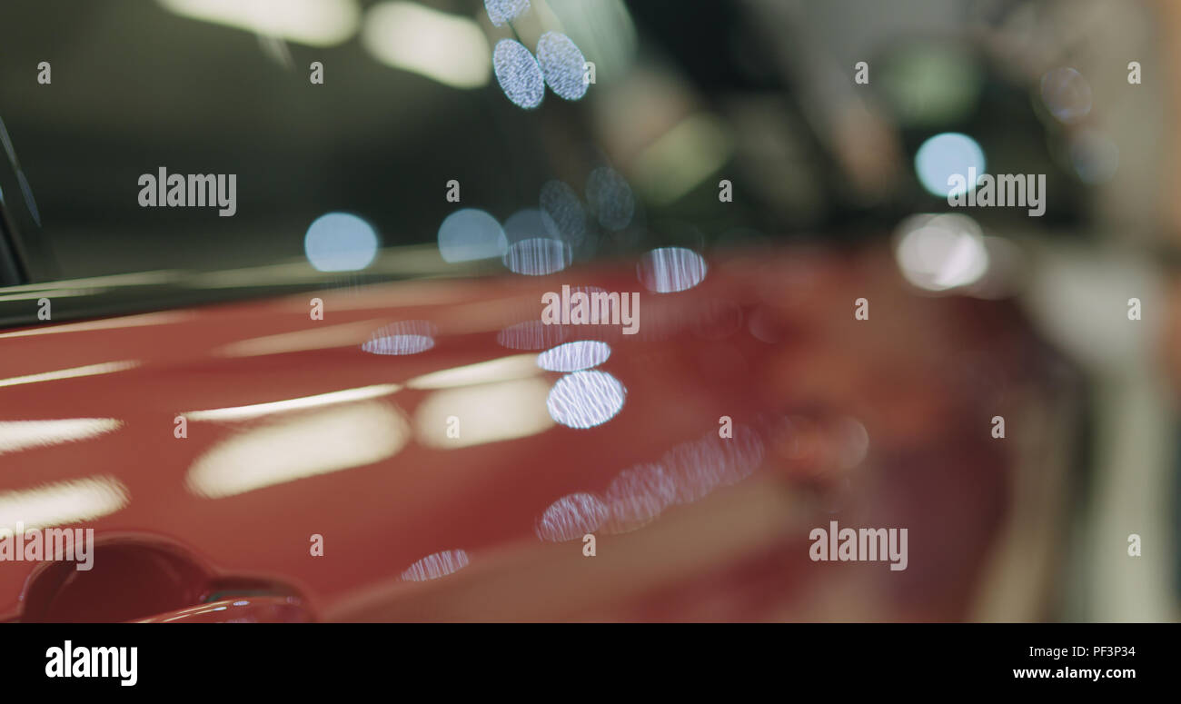 closeup blurred background of red car in detailing center, wide photo ...