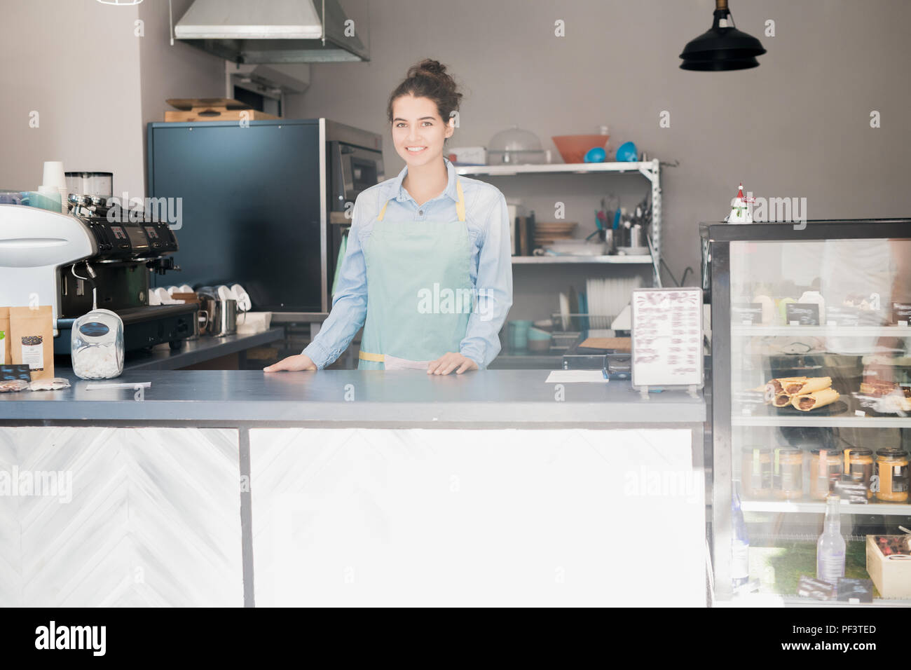 Smiling Shopkeeper Behind Counter Stock Photo - Alamy