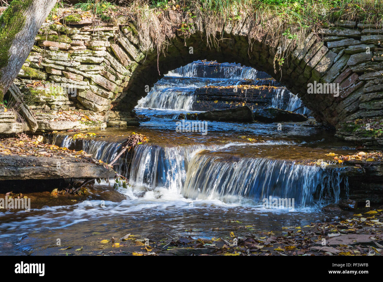 Old arched bridge with waterfall Stock Photo - Alamy