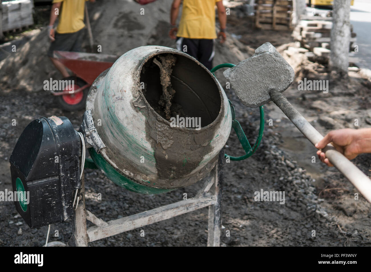 Construction worker add ingredients for mixing in the concrete mixer at ...