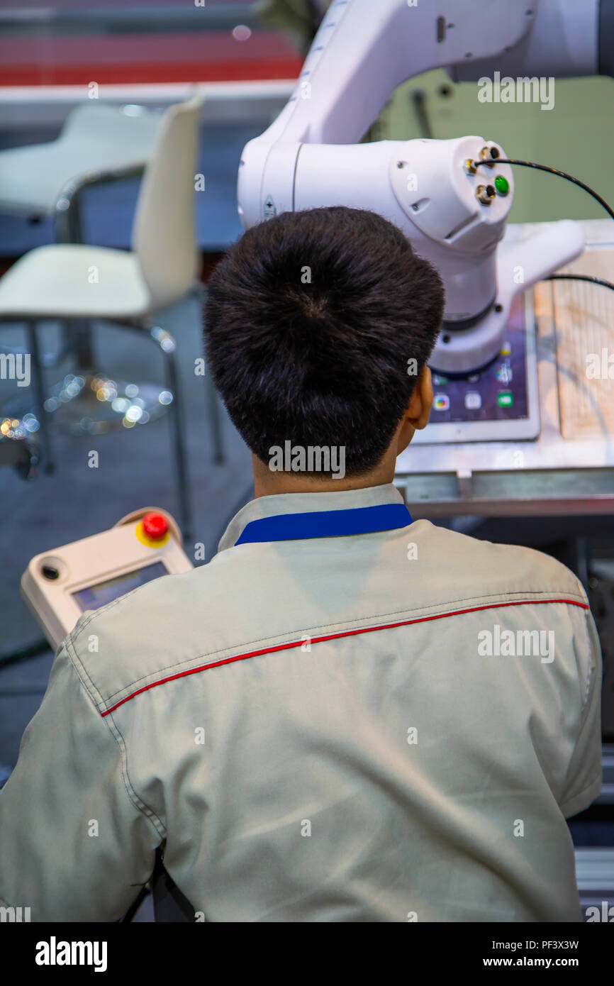 Worker control robot arm to loadind and un loading tablet Stock Photo ...