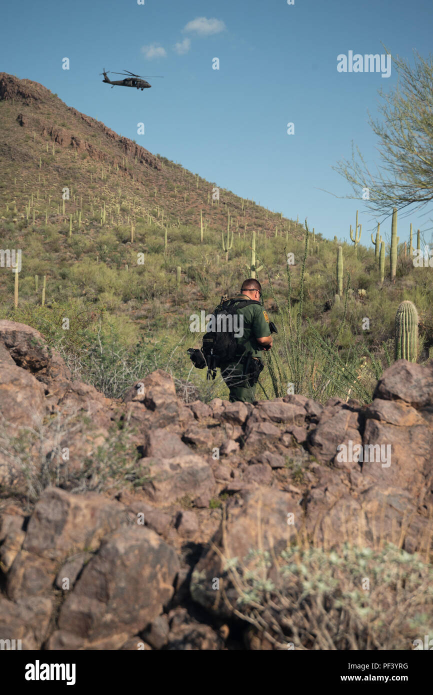 A Border Patrol agent patrols on foot as a National Guard UH-60 ...