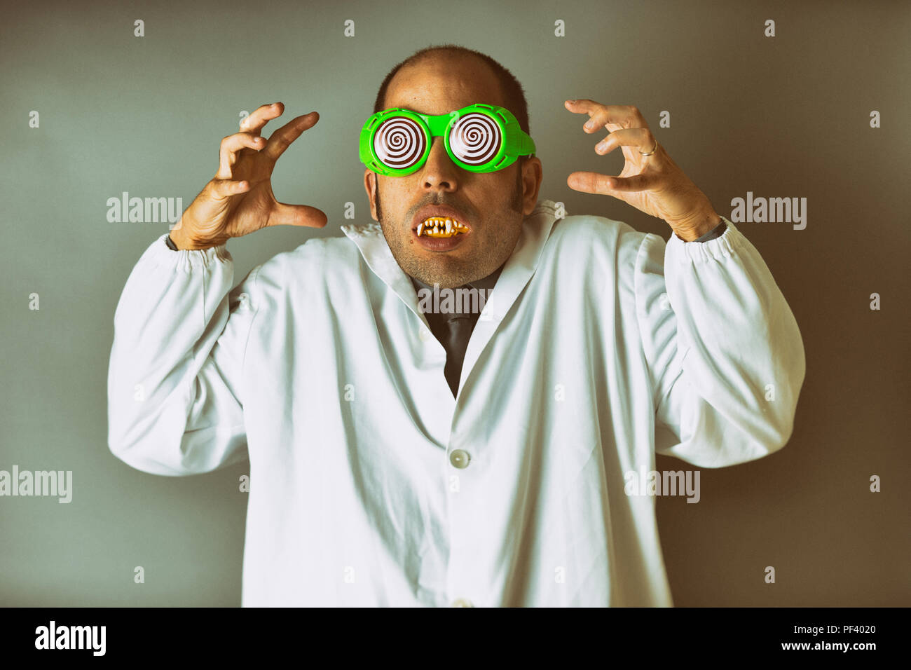 A man dressed as a mad scientist with a lab coat, crazy glasses, and ...