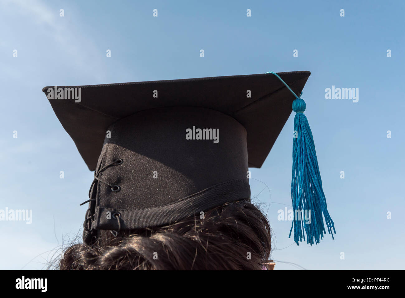 Graduation black tail cap with blue sky background Stock Photo - Alamy