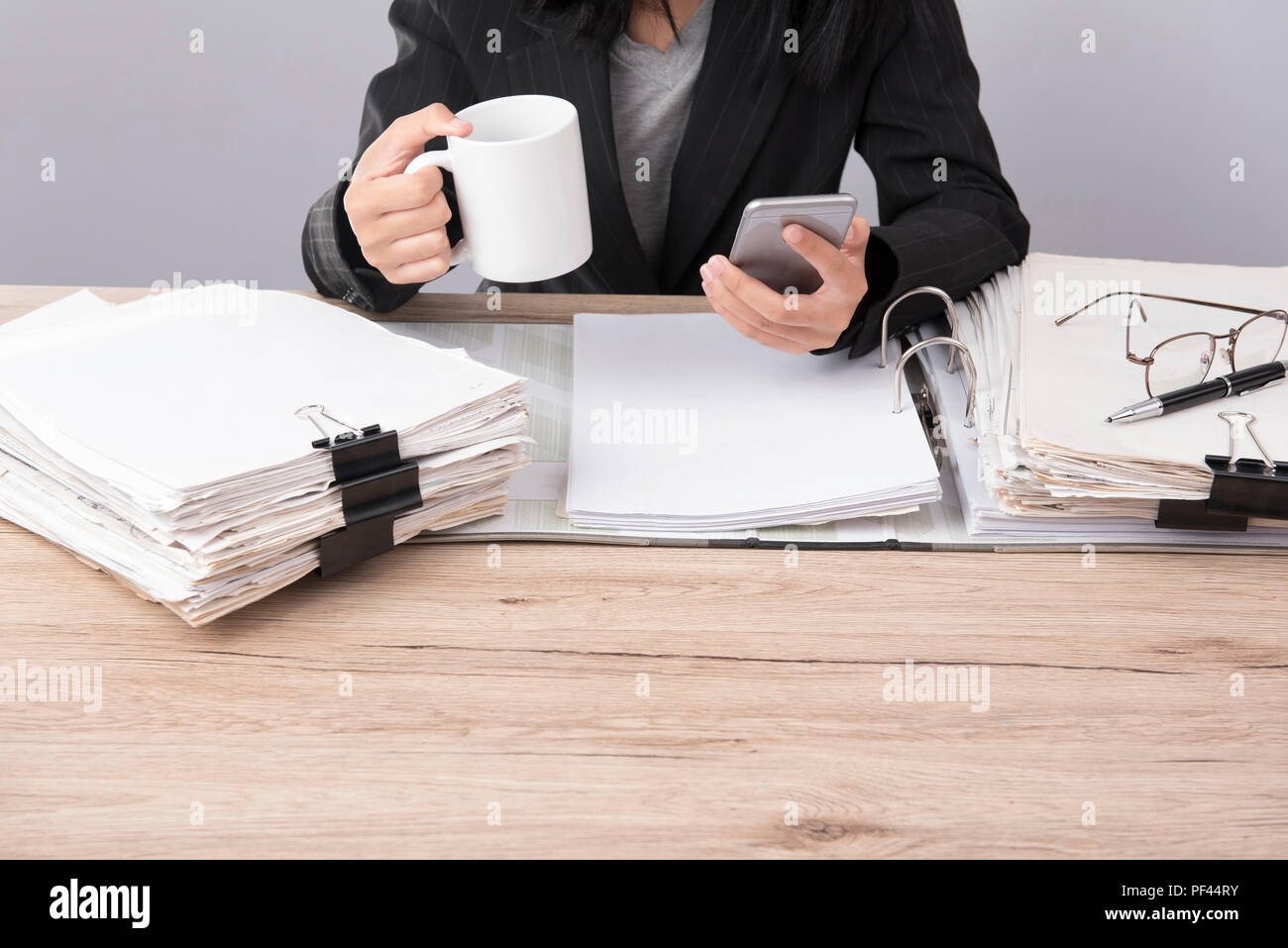 Business woman check the phone at work desk Stock Photo - Alamy