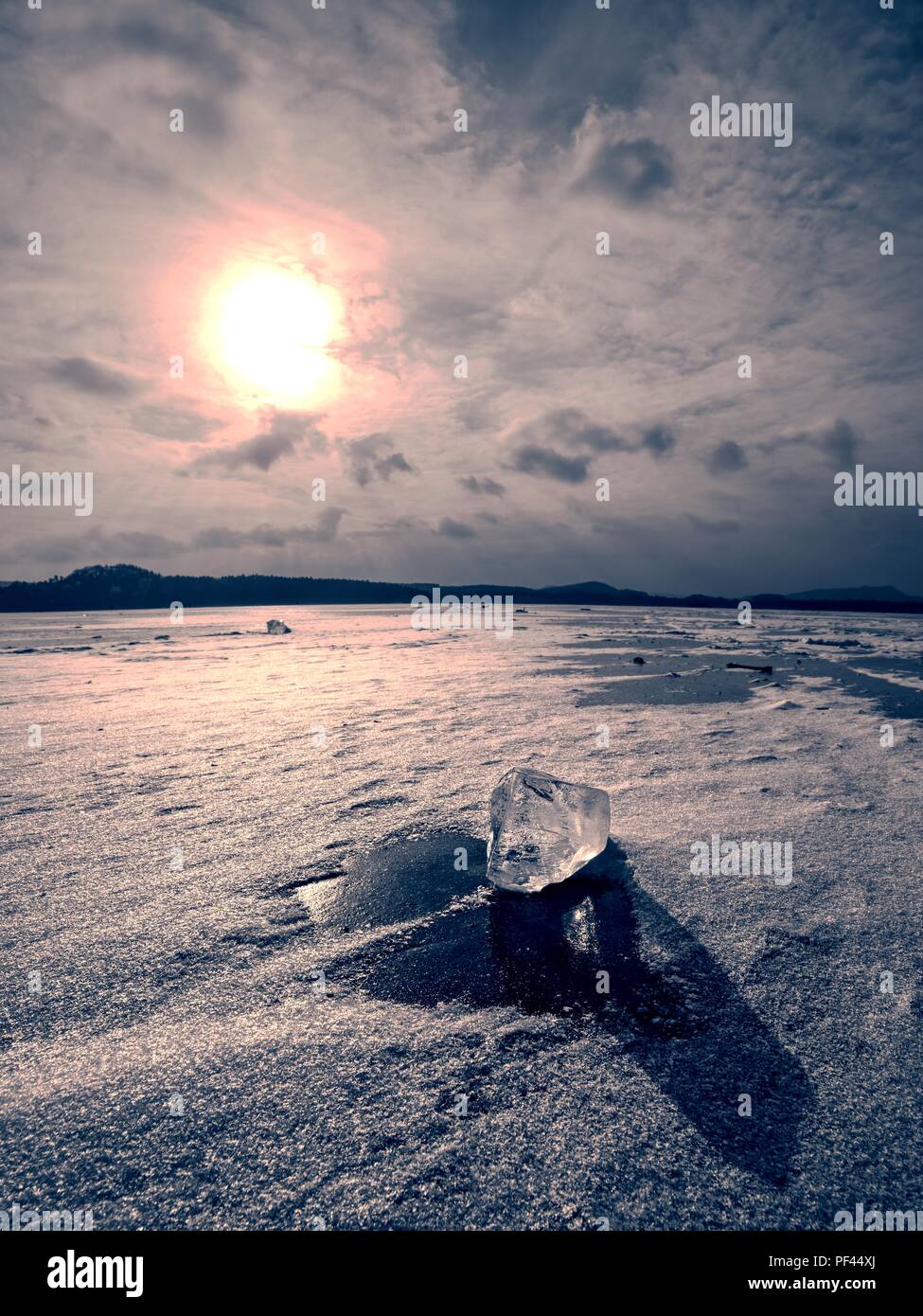 Ice breaking in pure nature. View over frozen water lake with sunset ...