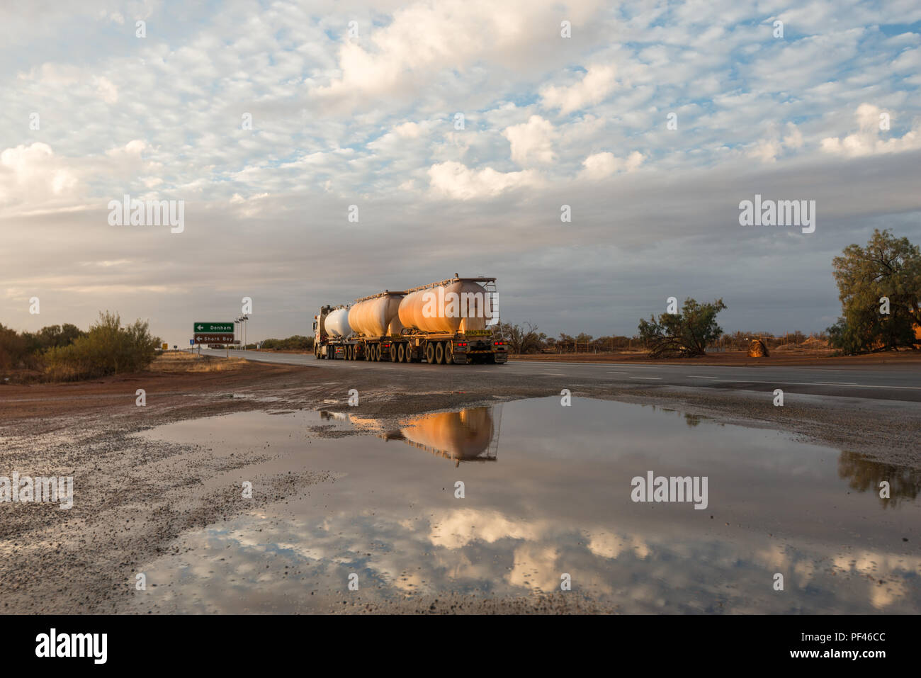 An Australian Road Train with 3 Trailer passing by and reflecting in a ...