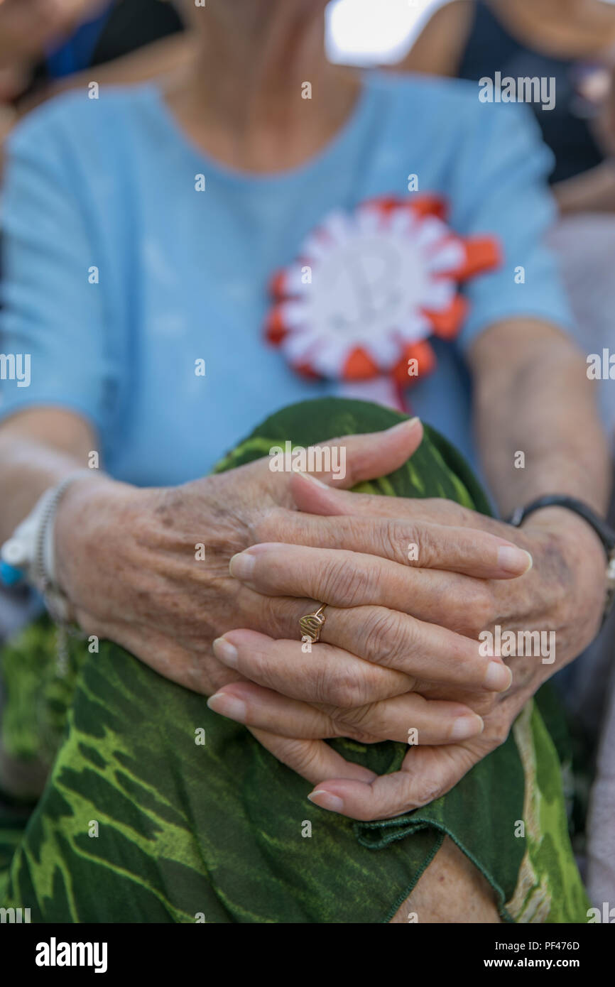 Hands of old woman with white and red cotillion with superposed anchor ...