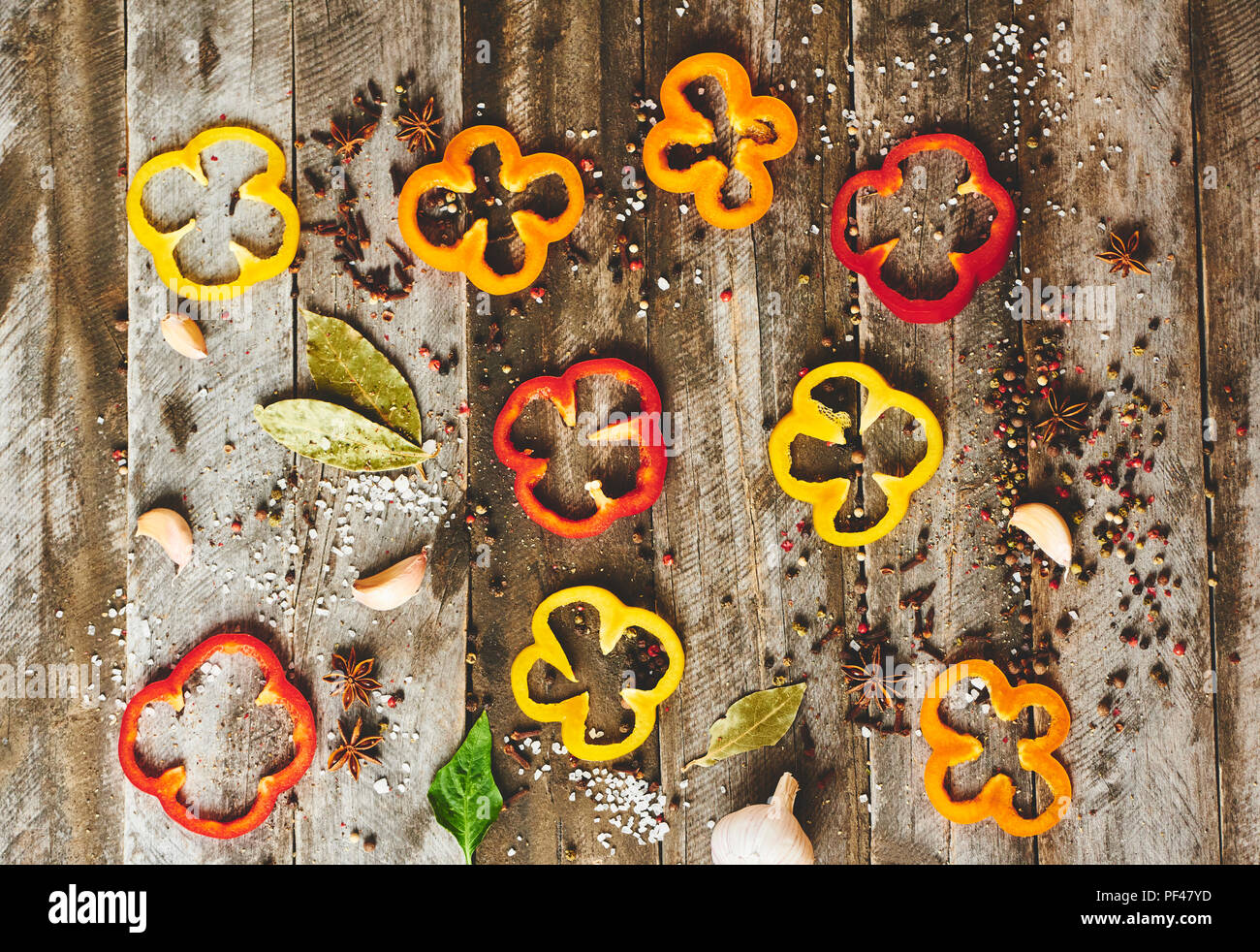 Chopped colorful bell pepper and spices on rustic wooden background ...