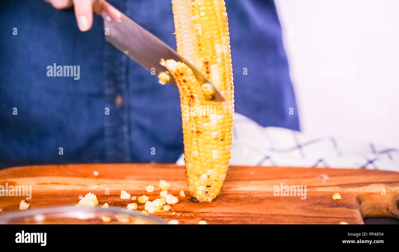 Step by step. Cutting the grilled corn of the cob ona wood cutting ...