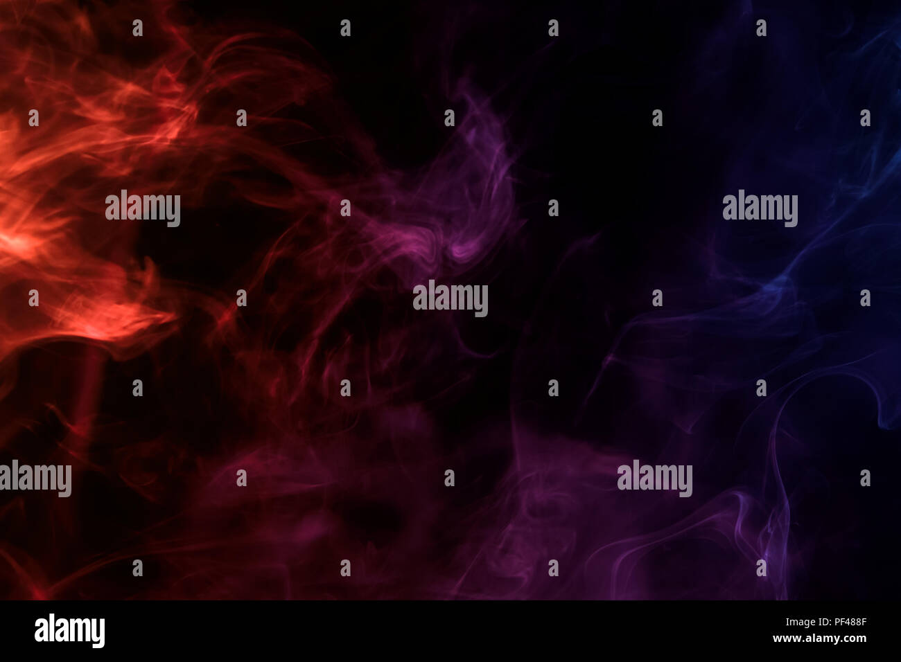 Dense multicolored smoke of red, blue and purple colors on a black ...
