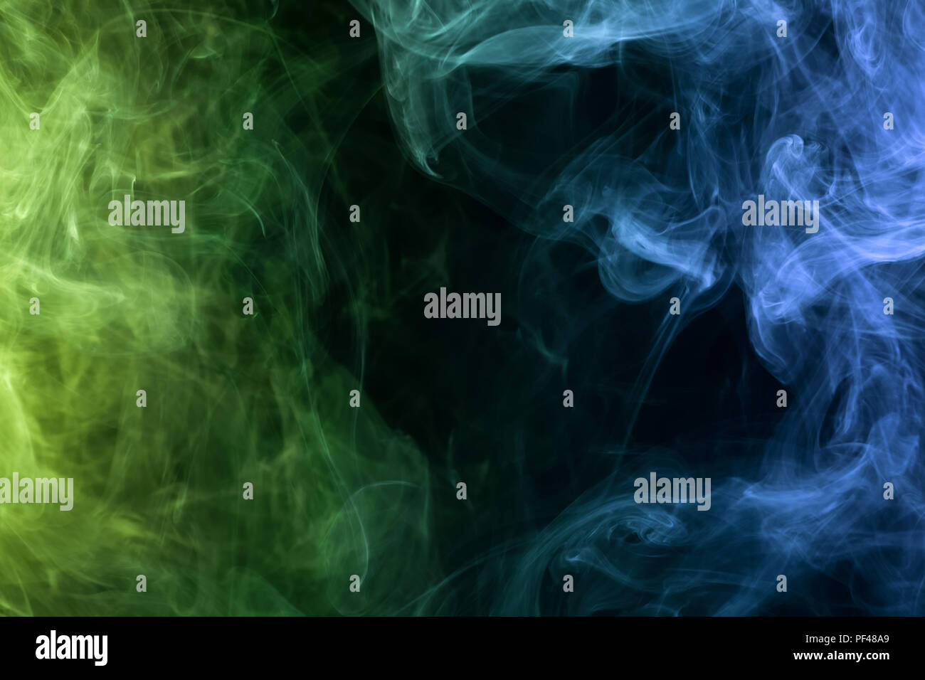 Thick colorful blue and green smoke on a black isolated background ...