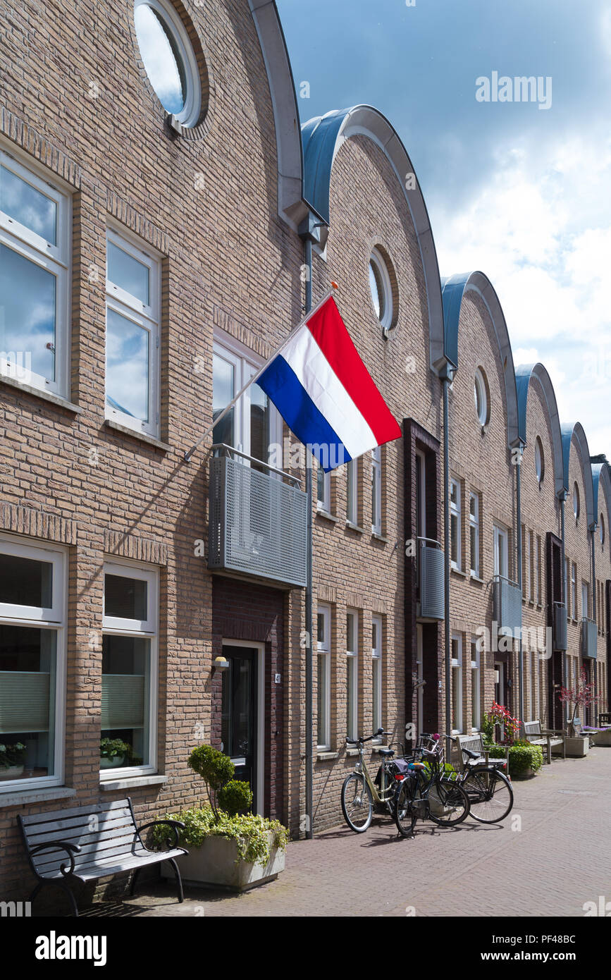 waving dutch flag on facade of a townhouse Stock Photo - Alamy
