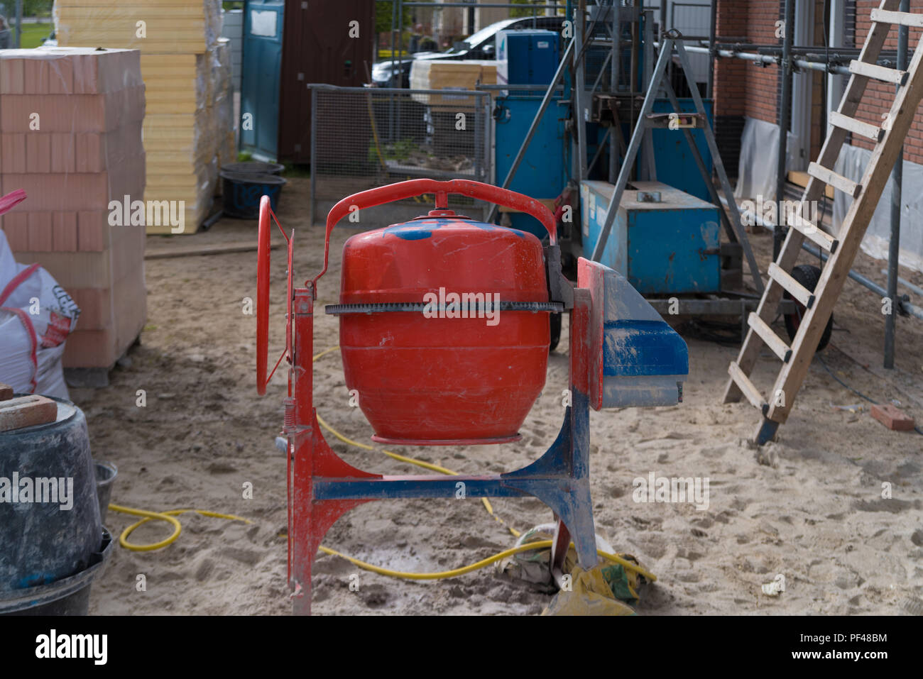 red cement mixer on a construction site Stock Photo - Alamy