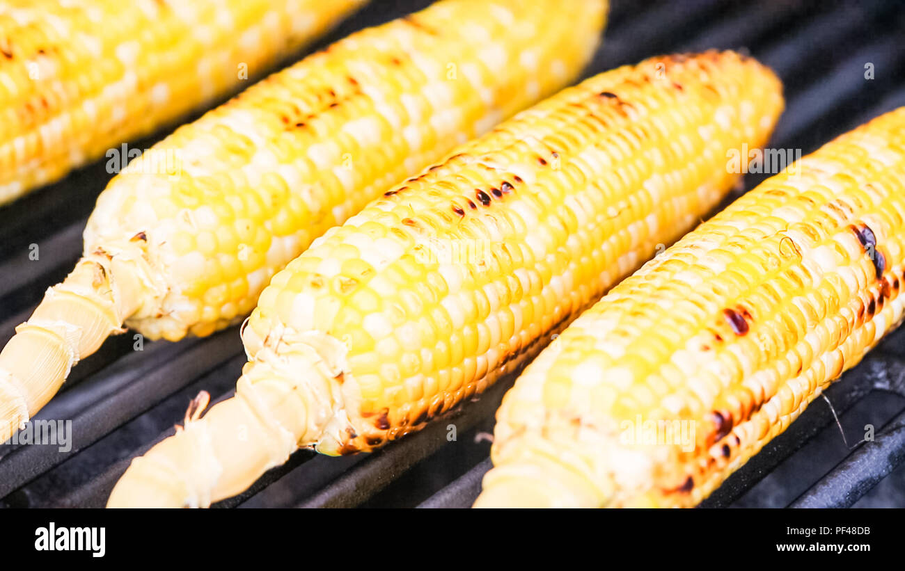 Step by step. Grilling organic corn on outdoor gas grill Stock Photo ...