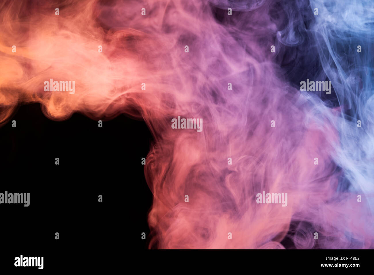 Thick red, pink and blue smoke on a black isolated background ...