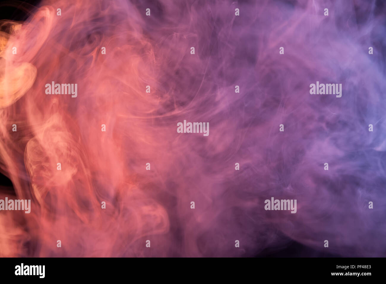 Thick red, pink and blue smoke on a black isolated background ...