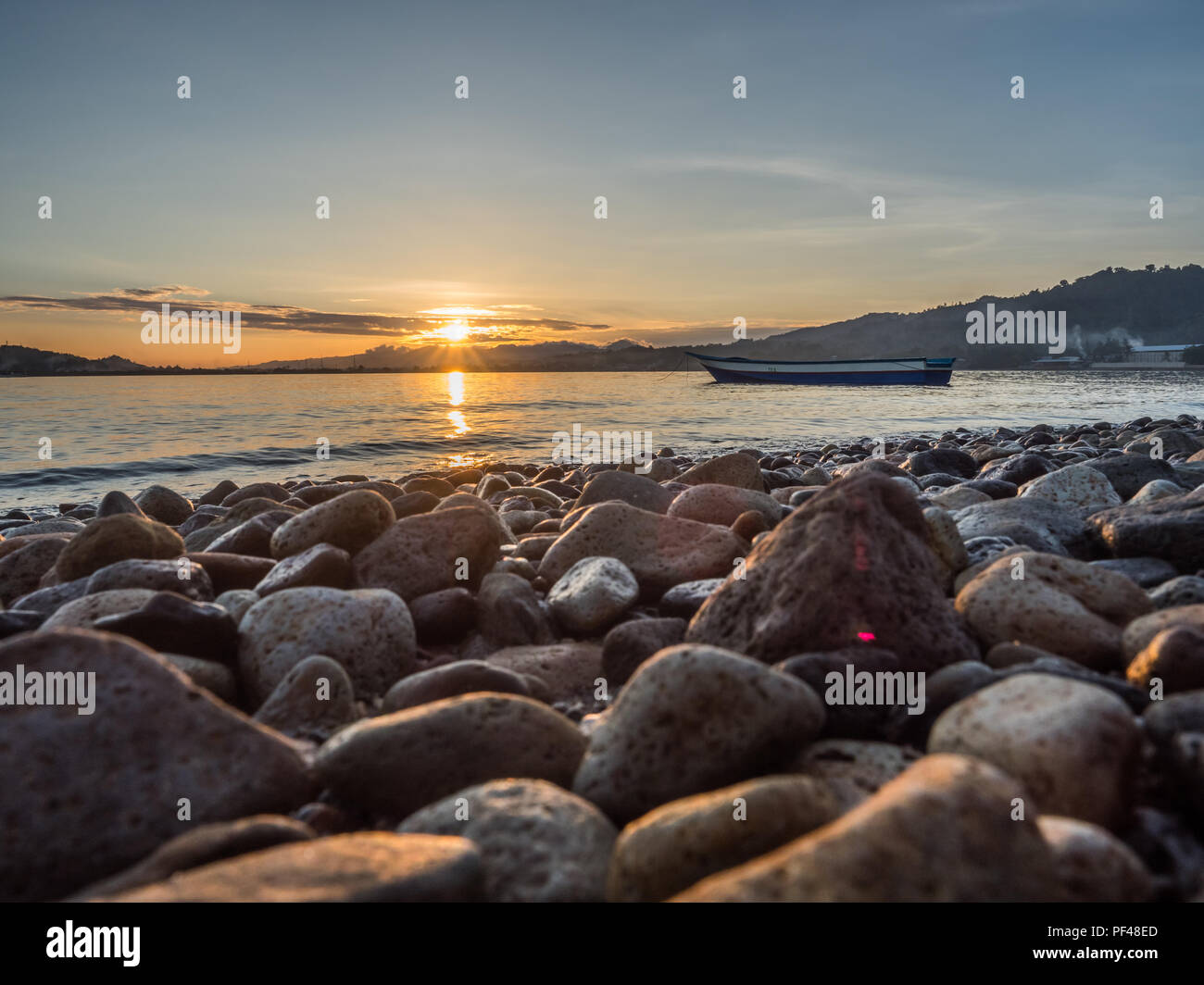 Tropical sunset at the stone beach on Ambon Island. Indonesia, Maluku ...