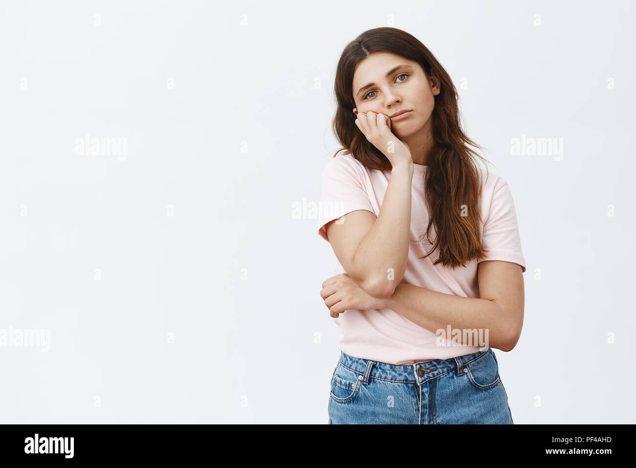 Studio shot of bored indifferent brunette woman with long hair in ...