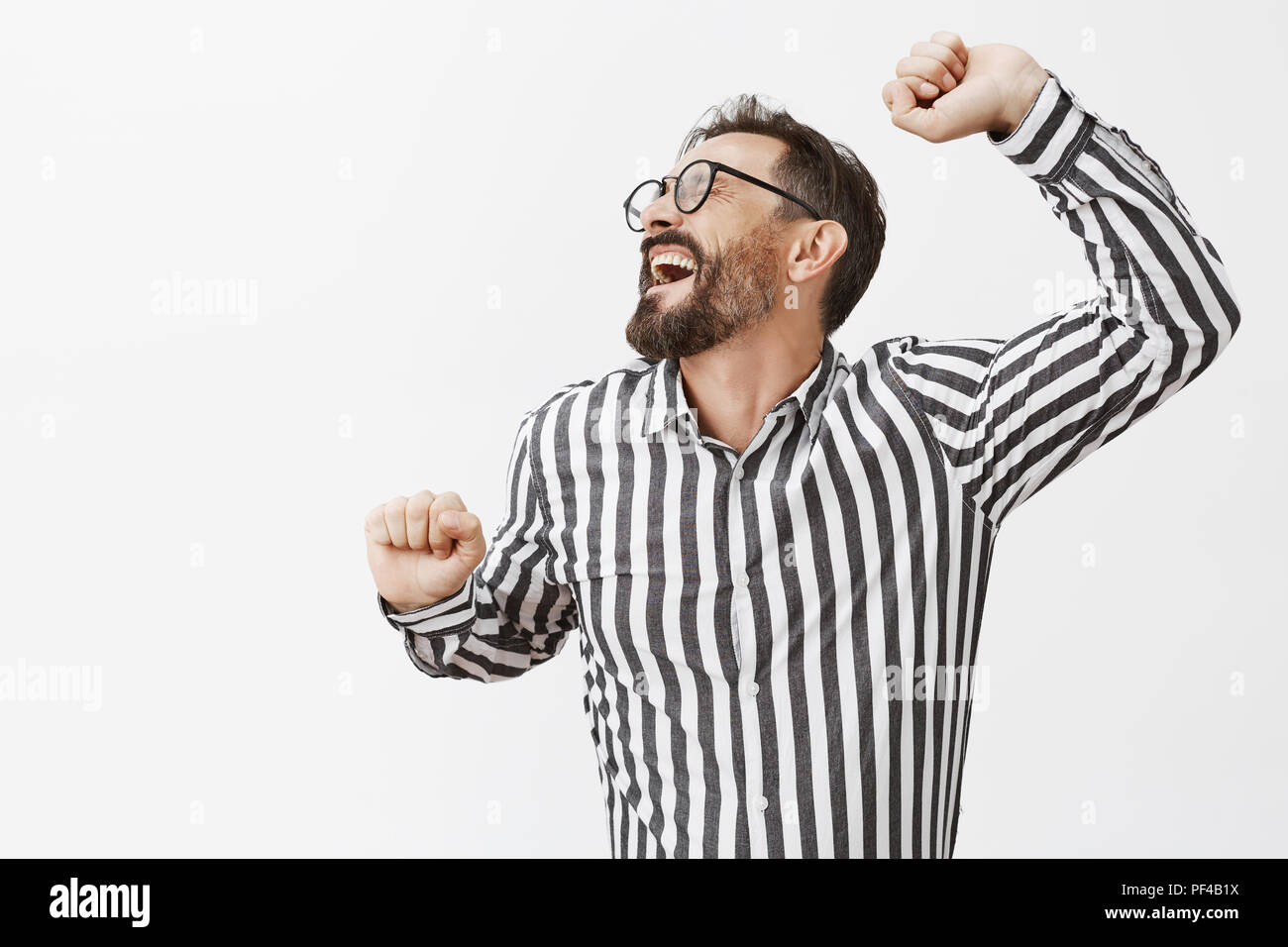 Happy tired man stretching while getting up from chair in office, going ...