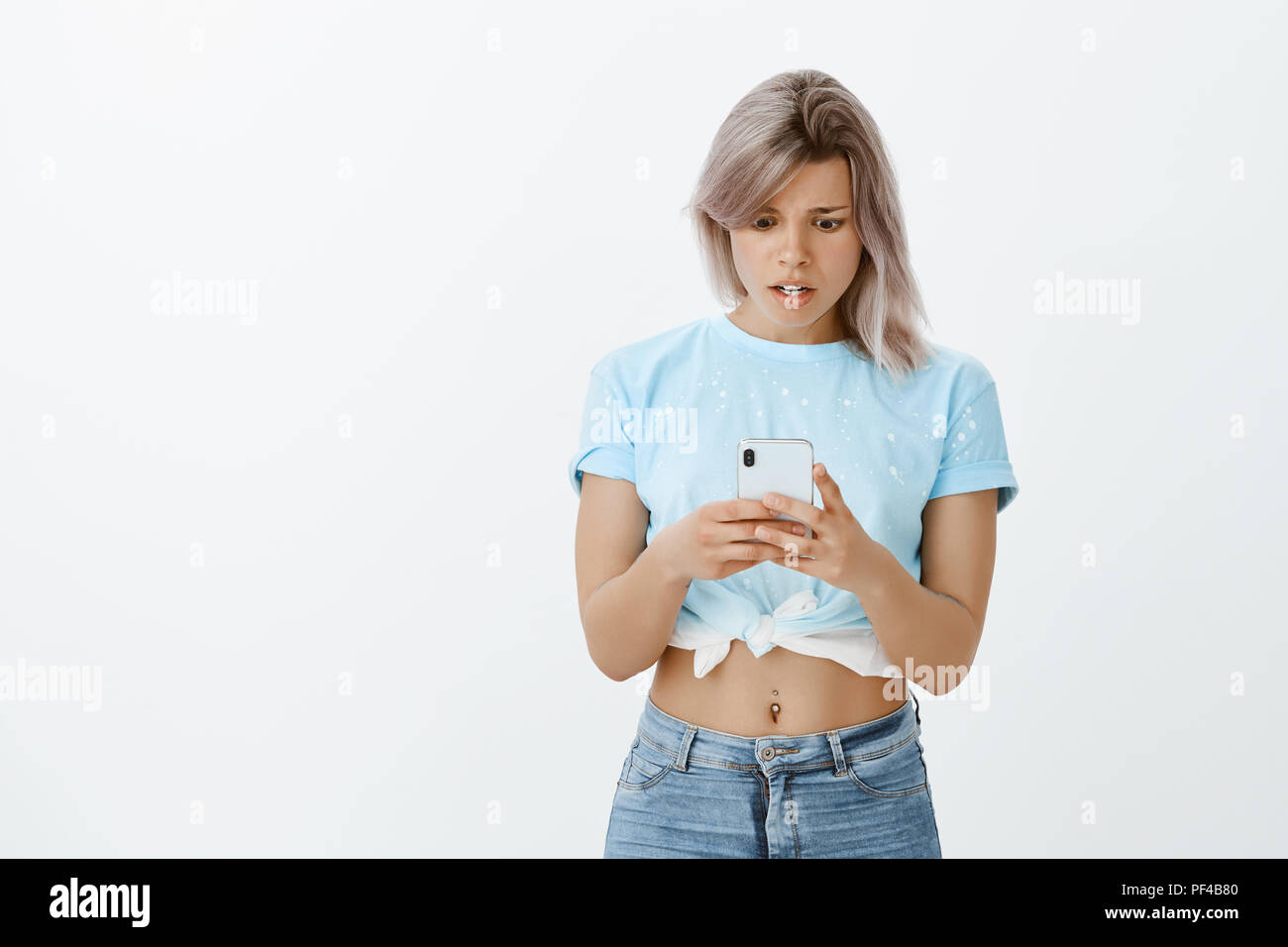 Indoor shot of stunned confused attractive woman with blond hair ...