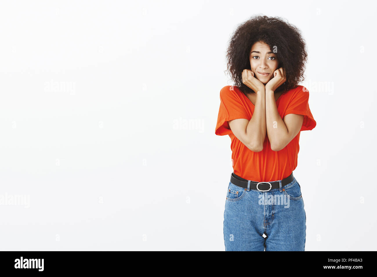 Studio shot of timid insecure attractive curly-haired female student in ...