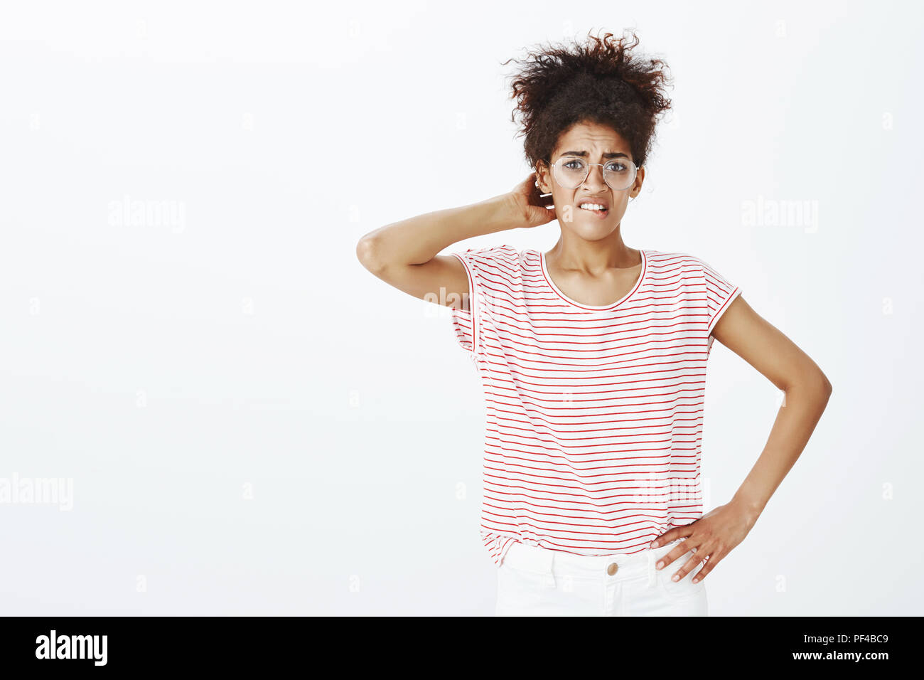 Troubled unsure attractive girlfriend in glasses and striped t-shirt ...