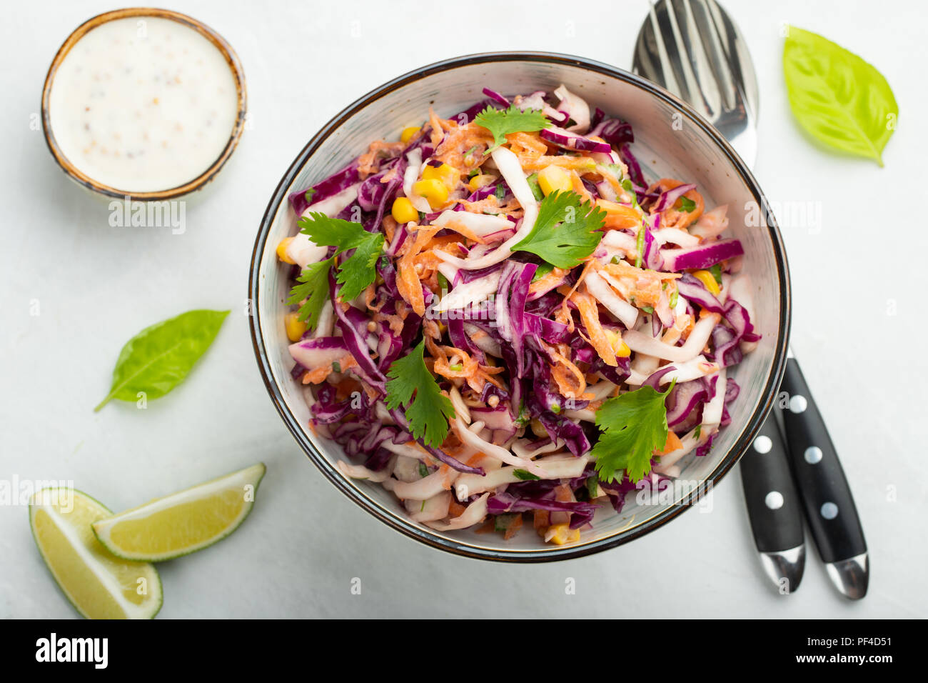 Purple cabbage and carrot salad with mayonnaise in a white bowl on a ...