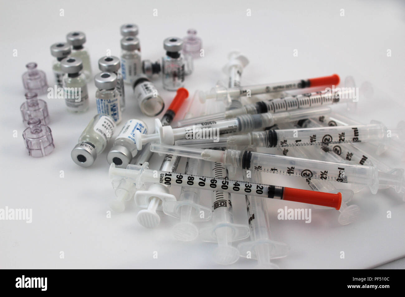 A pile of syringes and vials on a white background. IVF treatment ...
