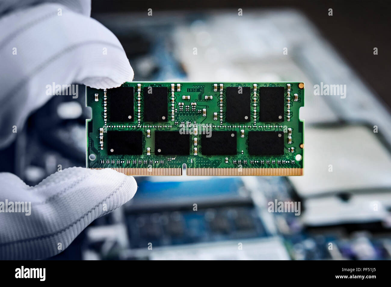 Hand with memory on a computer motherboard. RAM in hand on the ...