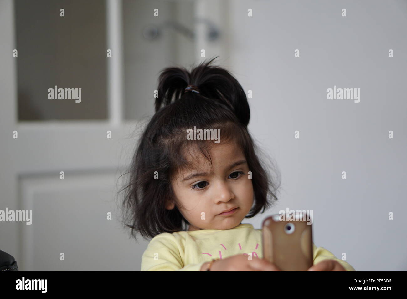 Small girl holding mobile hi-res stock photography and images - Alamy