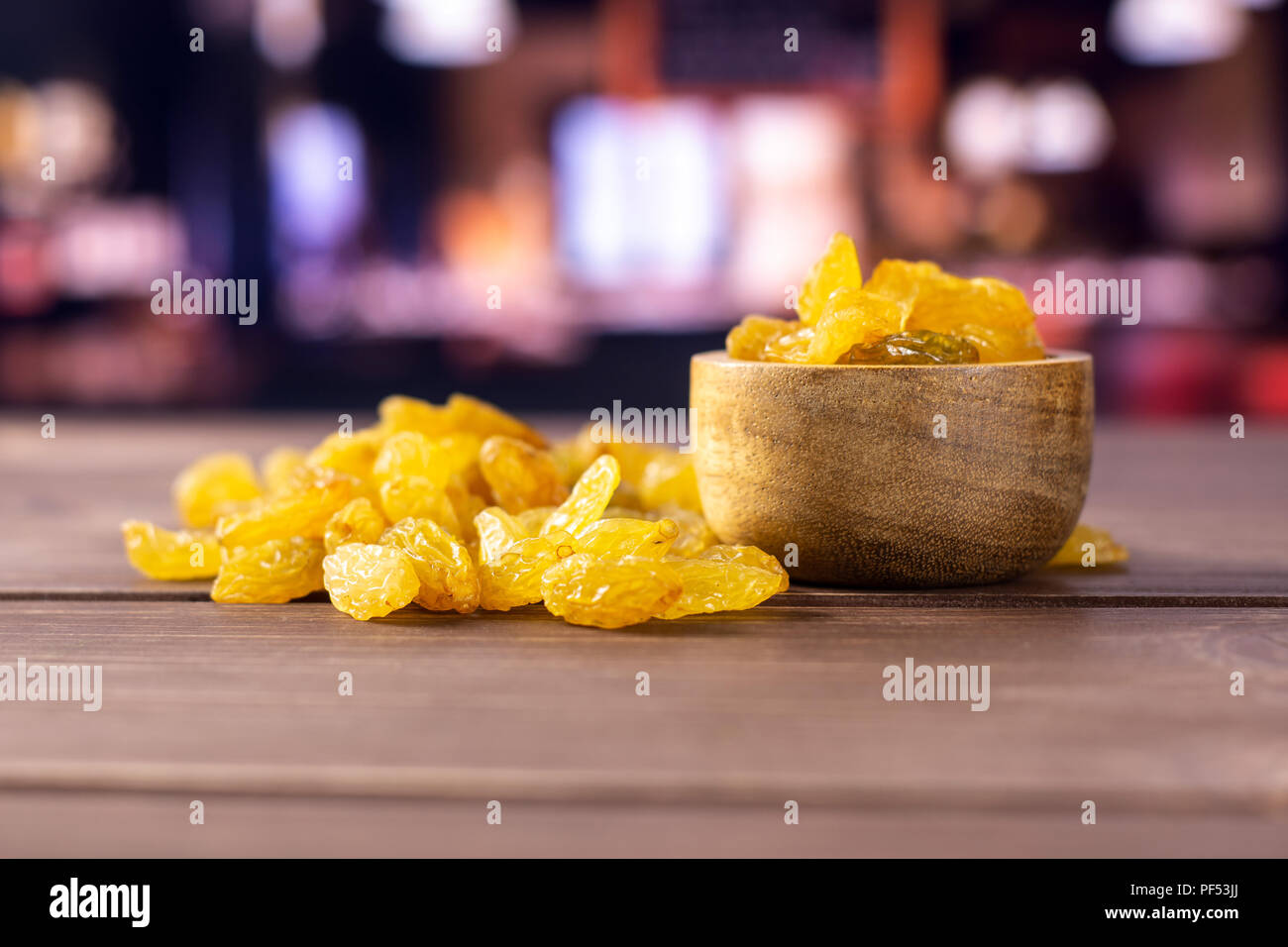 Lot of whole dry golden raisins sultana variety with wooden bowl with ...